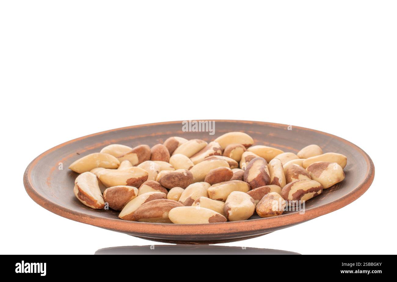 Brazil nuts without shells in a clay plate, macro, isolated on white ...