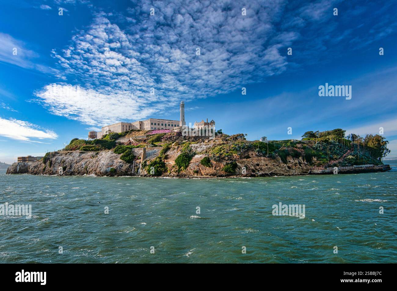 A breathtaking view of Alcatraz Island under a blue sky and white ...