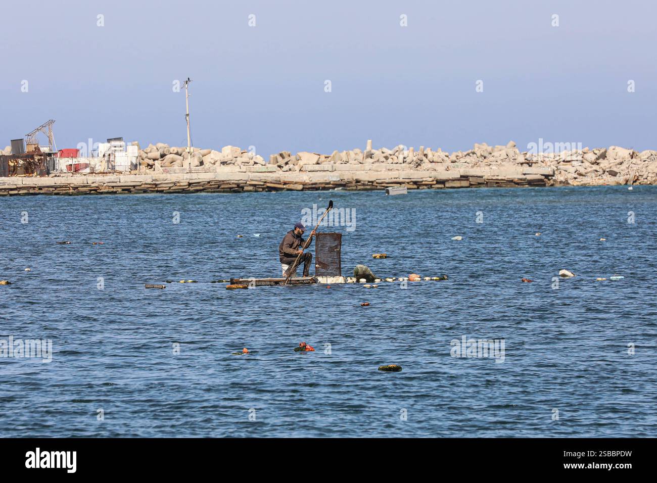 Fishermen paddle on makeshift boats with destroyed buildings seen in ...