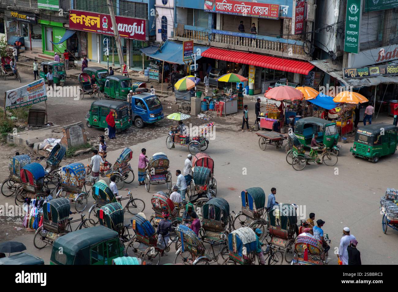 A busy road in Jurain, Dhaka, Bangladesh, filled with a crowd of ...