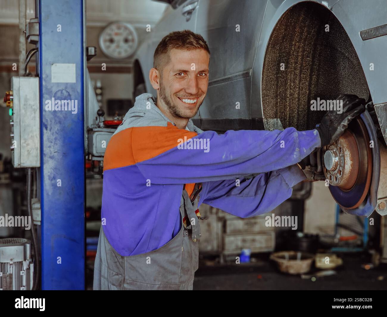 An automotive mechanic in his workshop, diligently repairing the brakes ...