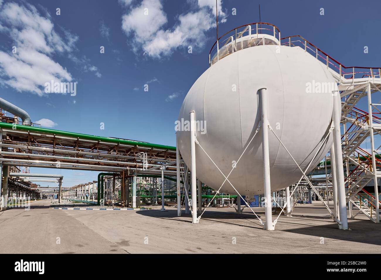 Natural gas holder at a chemical plant under clear blue skies ...