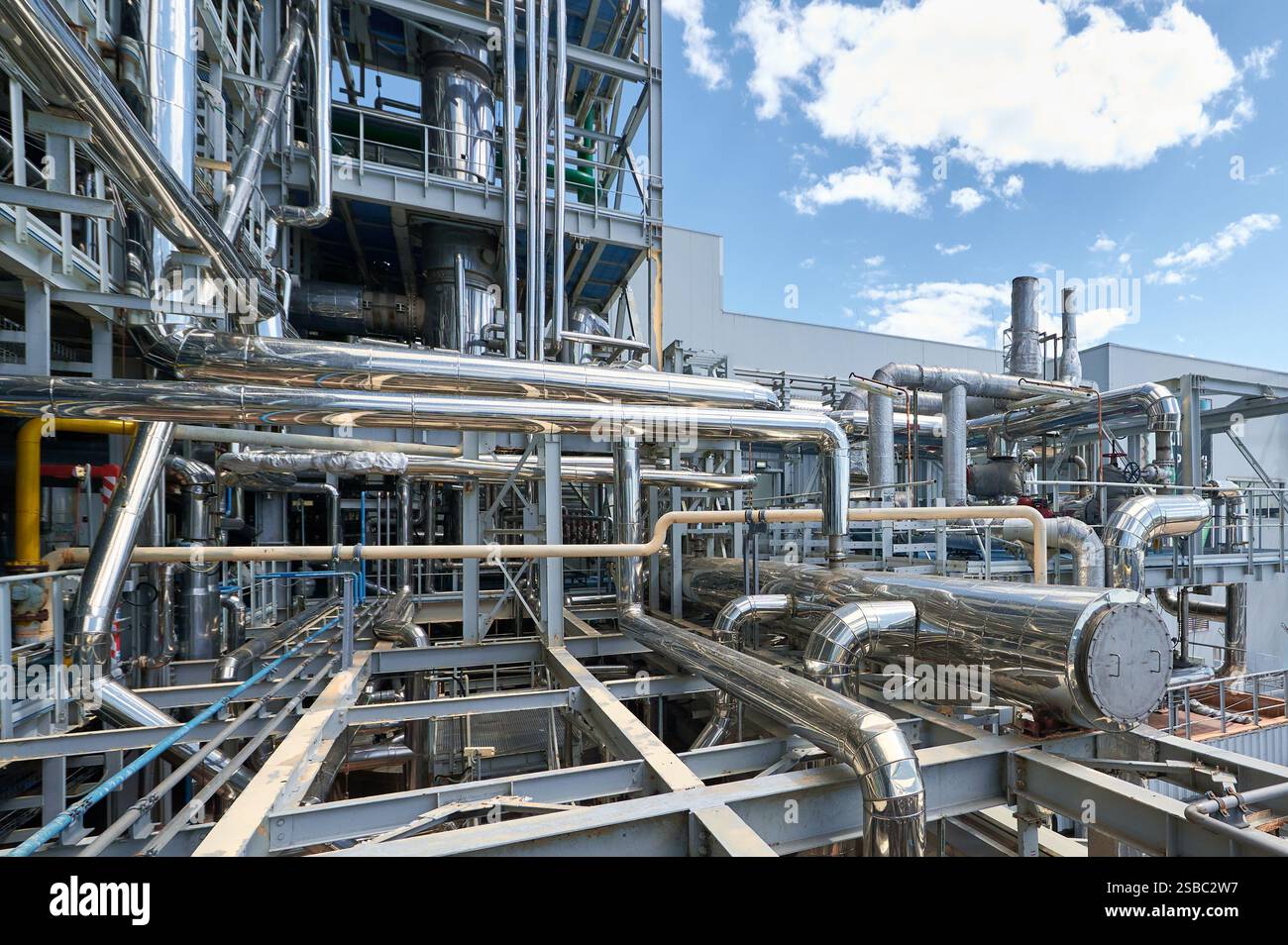 Pipelines and structures of a chemical plant under a clear blue sky ...