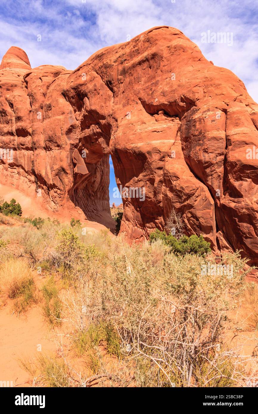 A large rock formation with a hole in it. The hole is surrounded by a ...