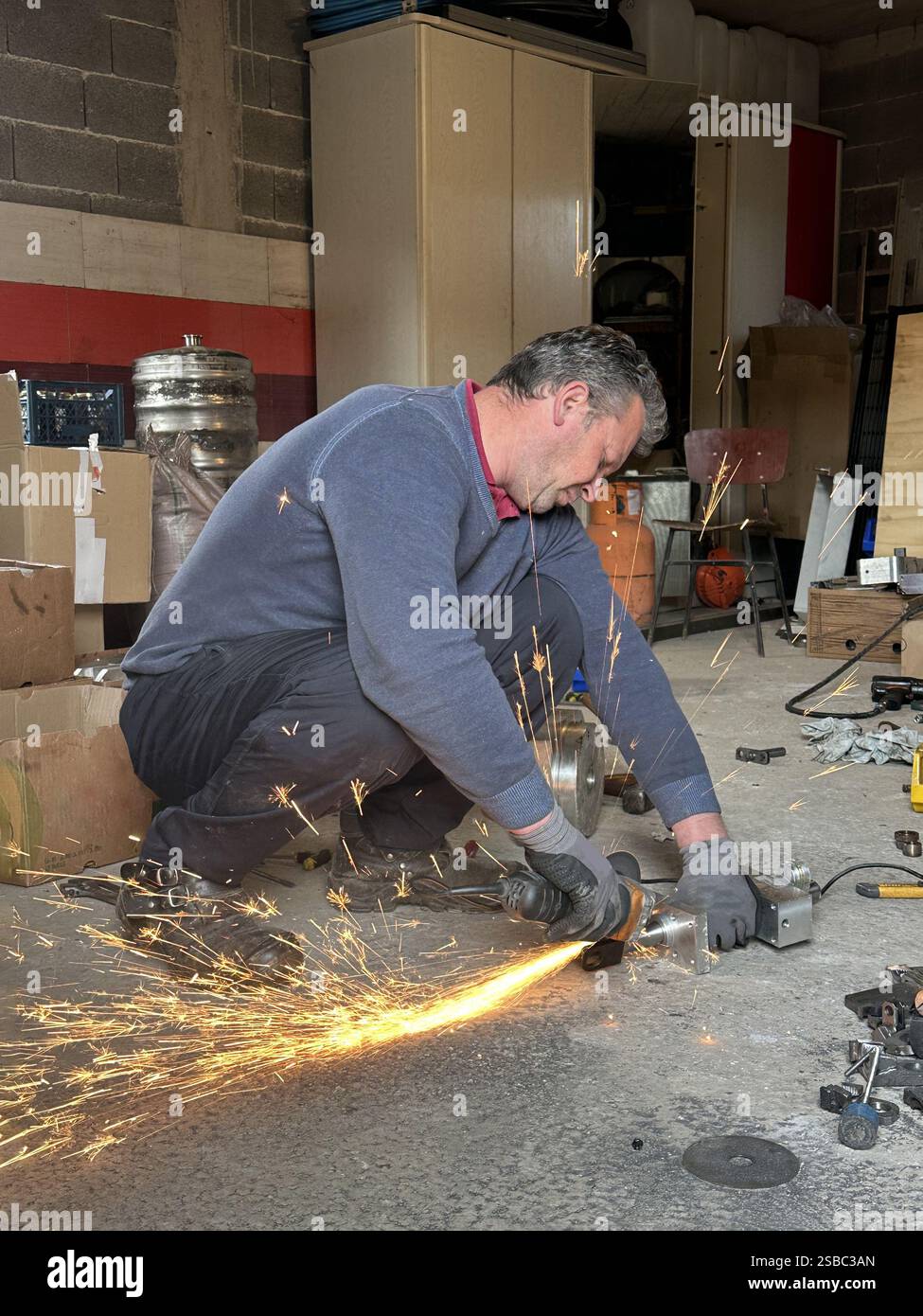 A man cutting aluminum parts in his garage to sell and support his ...
