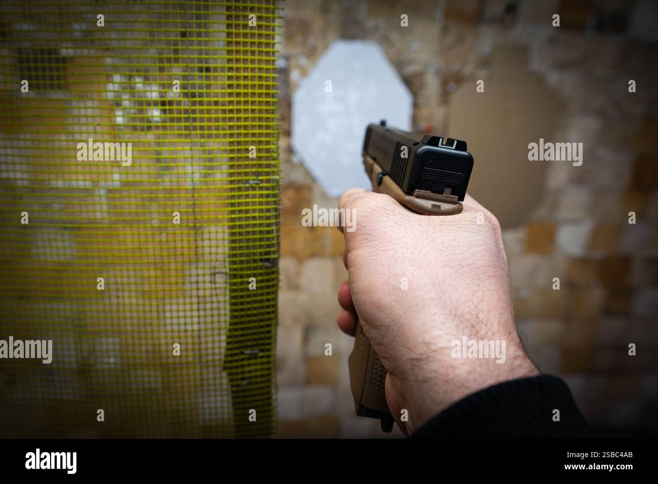 Pistol aiming at a target from behind cover in a shooting range, photo ...