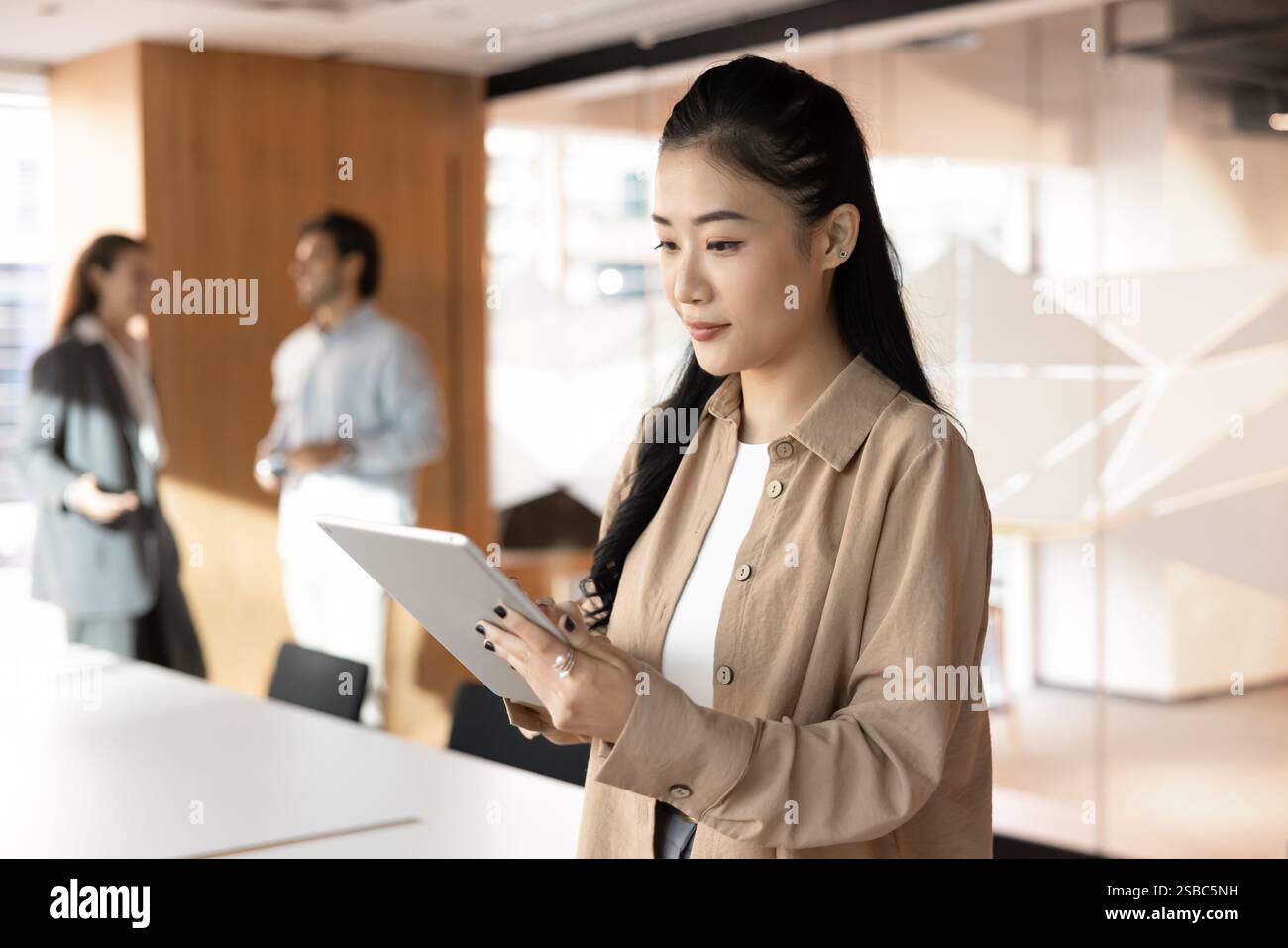 Focused young Asian manager girl using web technology on tablet Stock ...