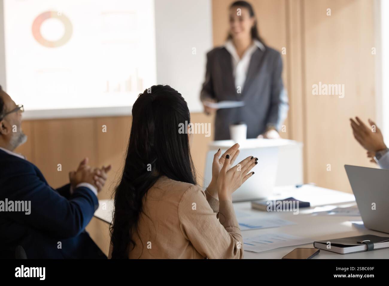 Diverse team of inspired business colleagues applauding project manager ...