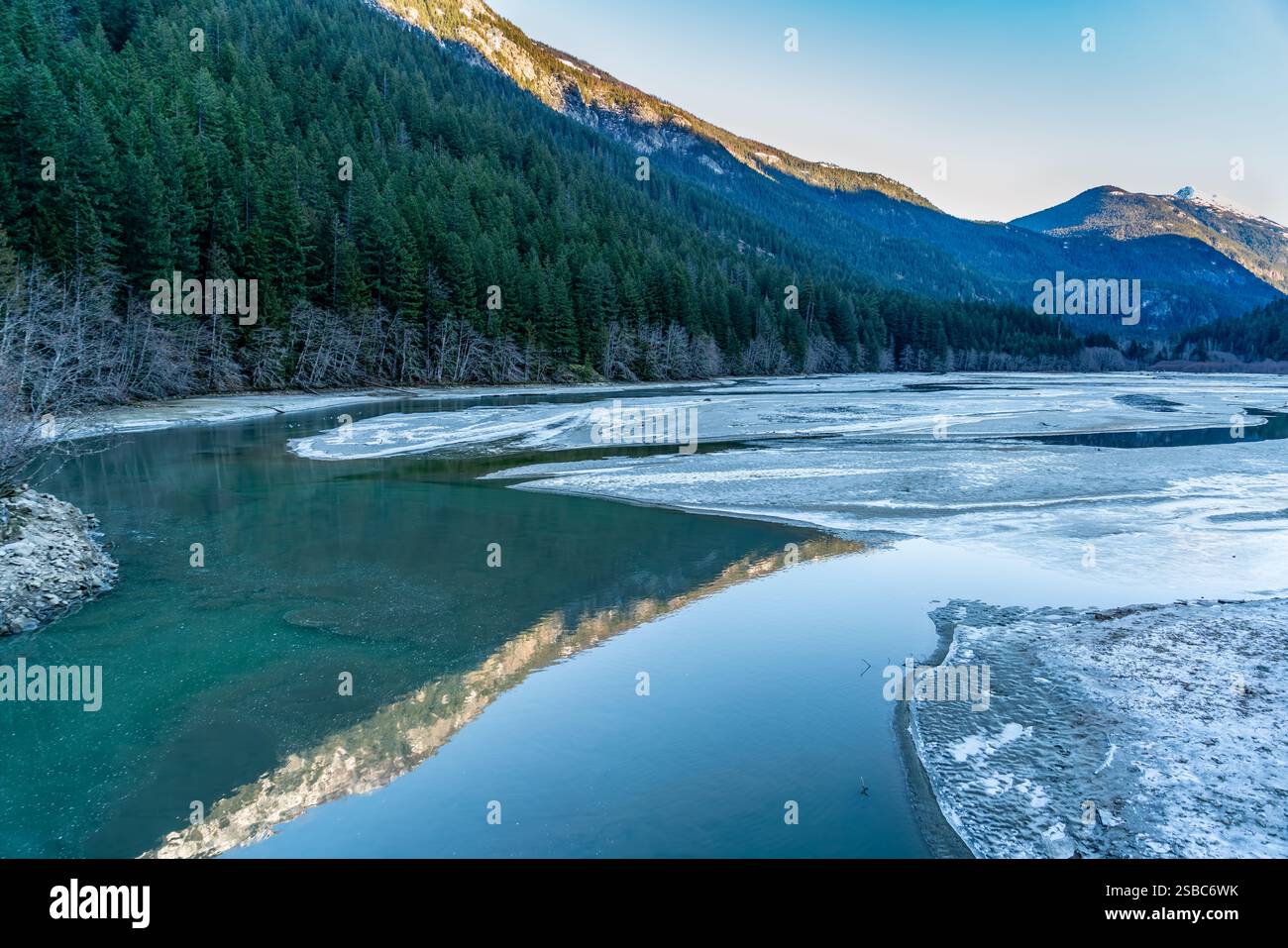 A landscape shot of the Skagit River in winter. with a layer of ice on ...