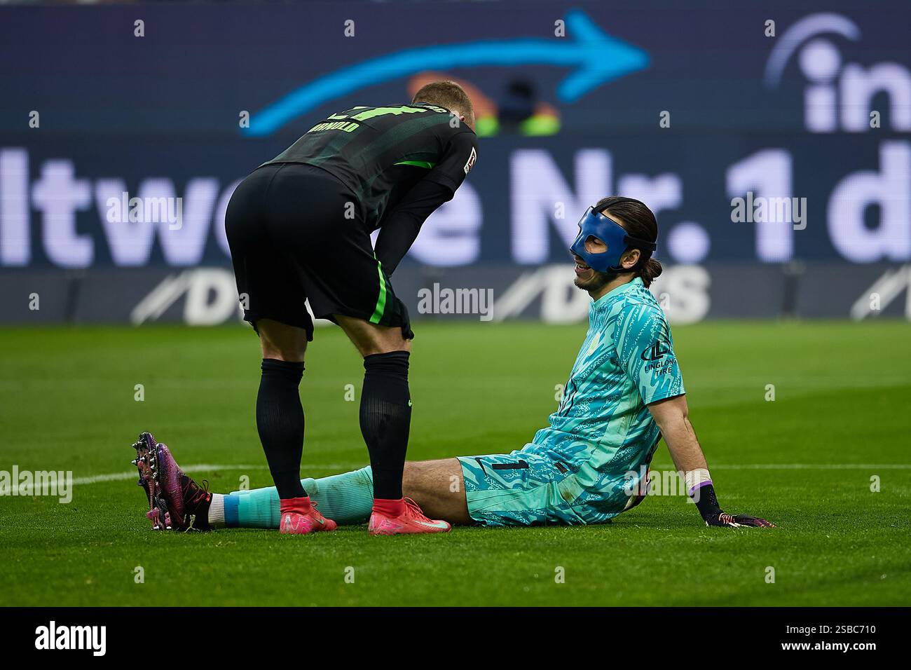 Kamil Grabara (VFL Wolfsburg, #01) liegt verletzt am Boden und muss ...