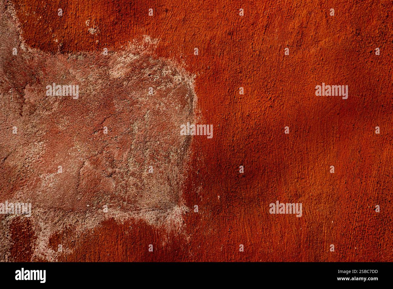 A close-up of a decorative red stucco wall showcasing its coarse ...