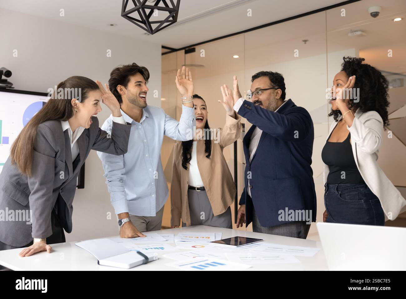 Diverse team of successful colleagues giving group high five Stock ...