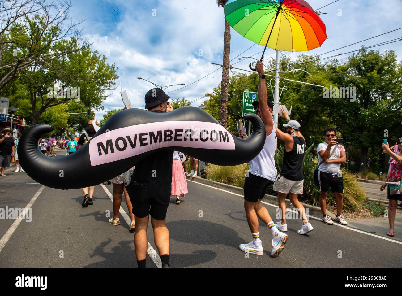 A participant carries a giant inflatable Movember mustache raising ...