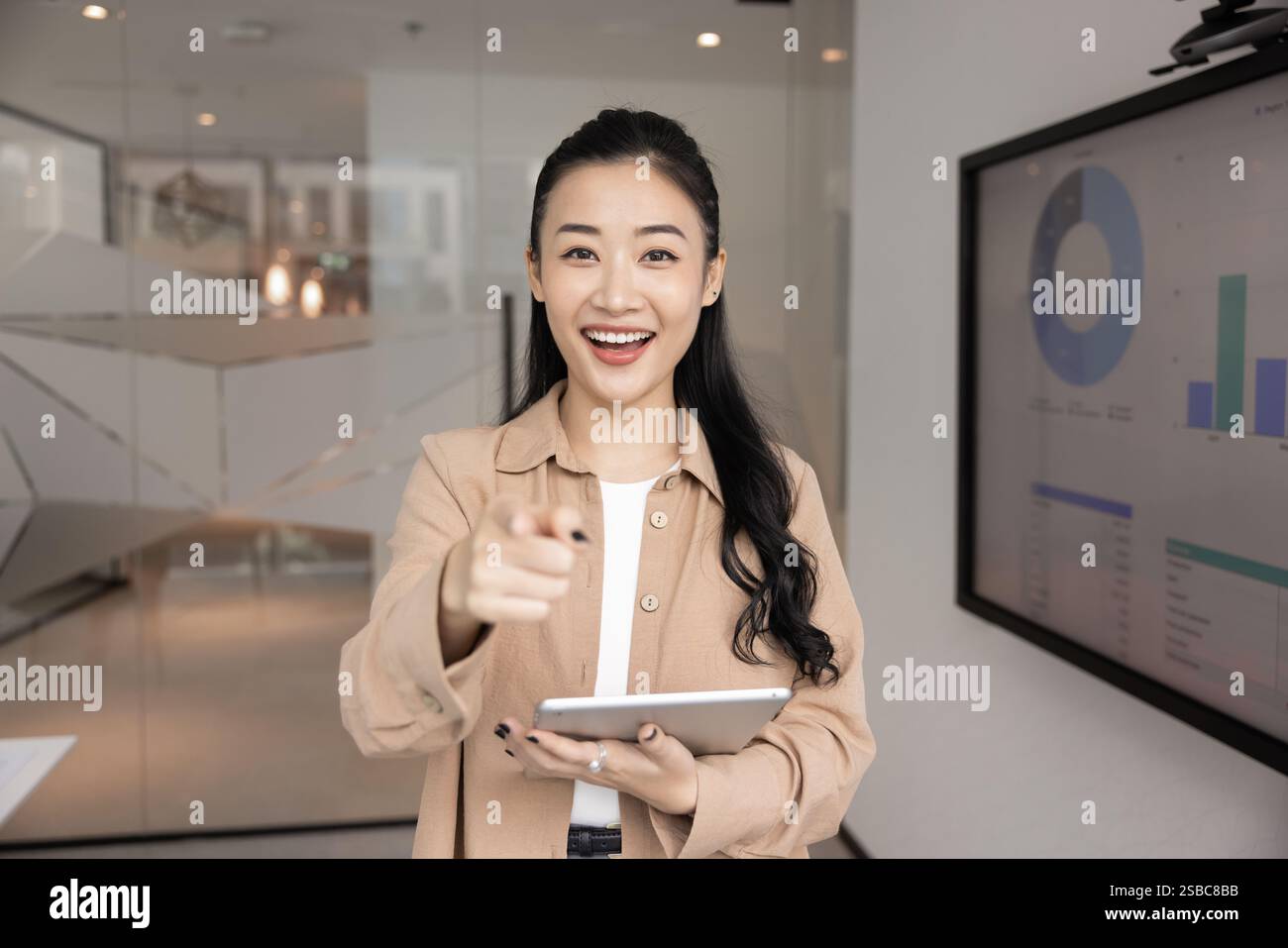 Cheerful young Asian recruit manager woman pointing finger at camera ...
