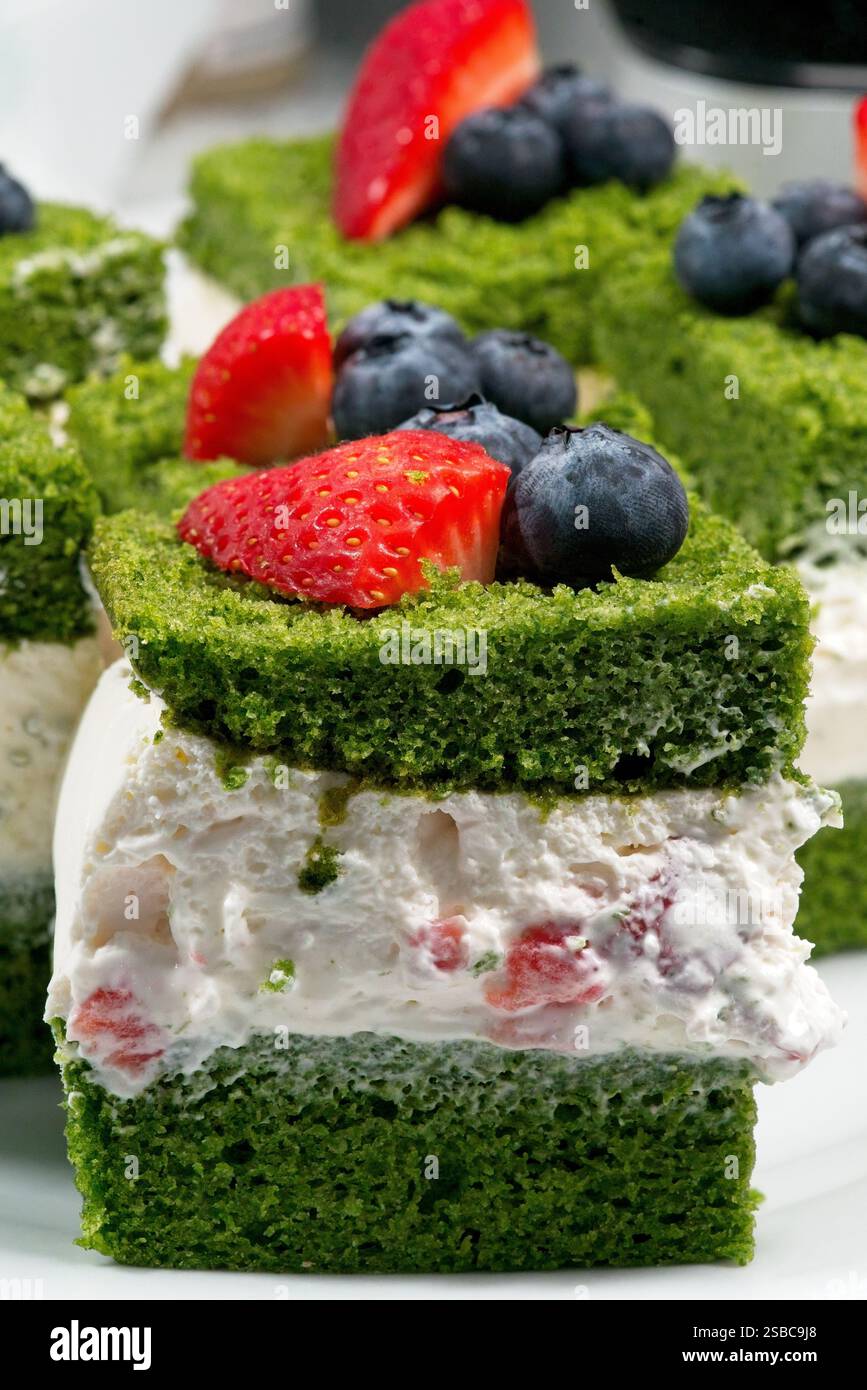 A green layer of sponge cake topped with whipped cream, blueberries ...