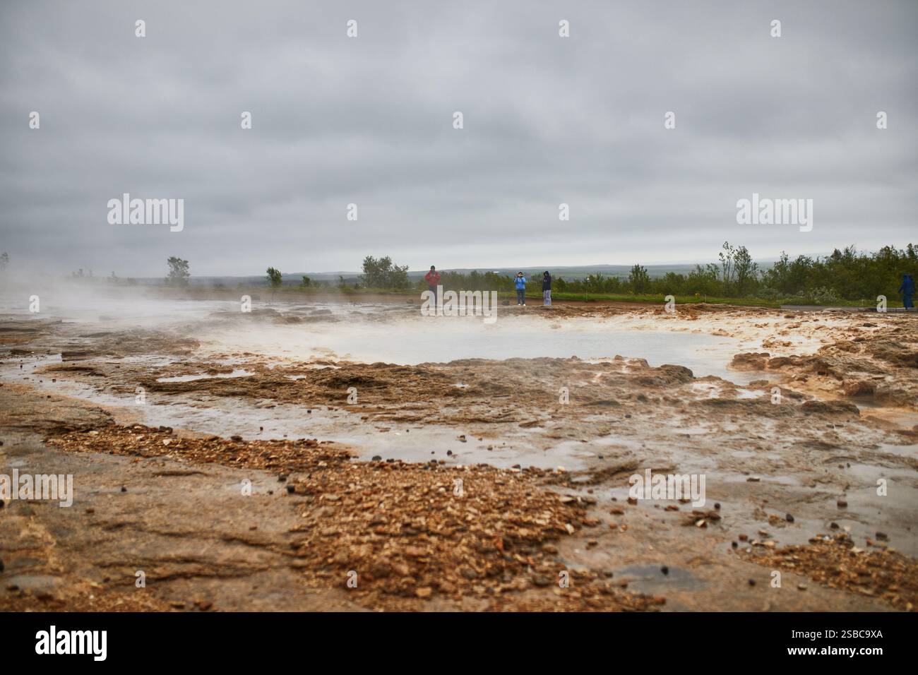 Famous Strokkur geyser between eruptions on a foggy rainy day in ...