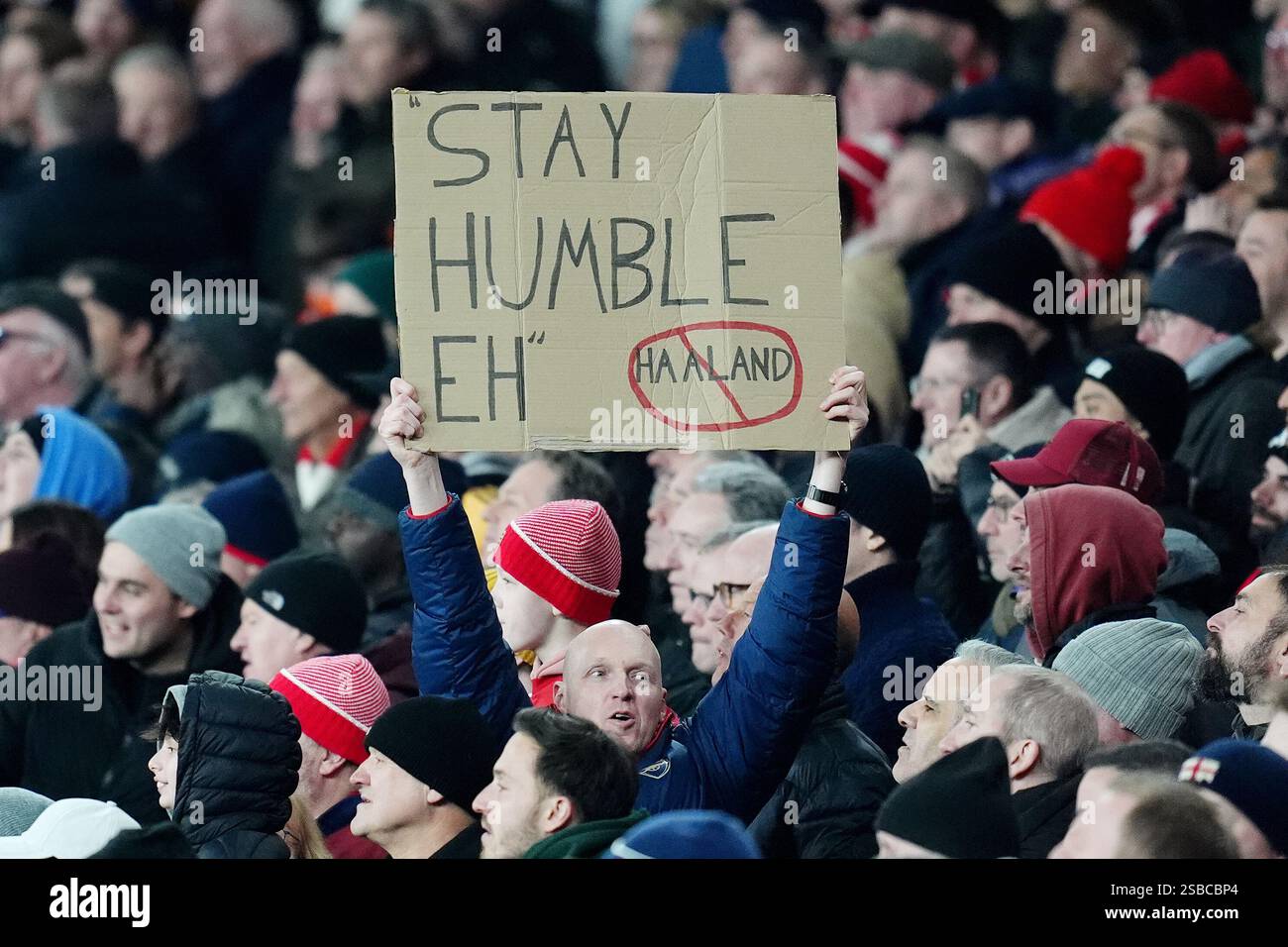 An Arsenal fan holds aloft a sign referencing Manchester City's Erling ...