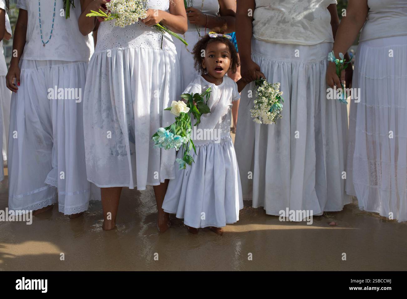 A child sings while holding flowers as offering for the African goddess ...