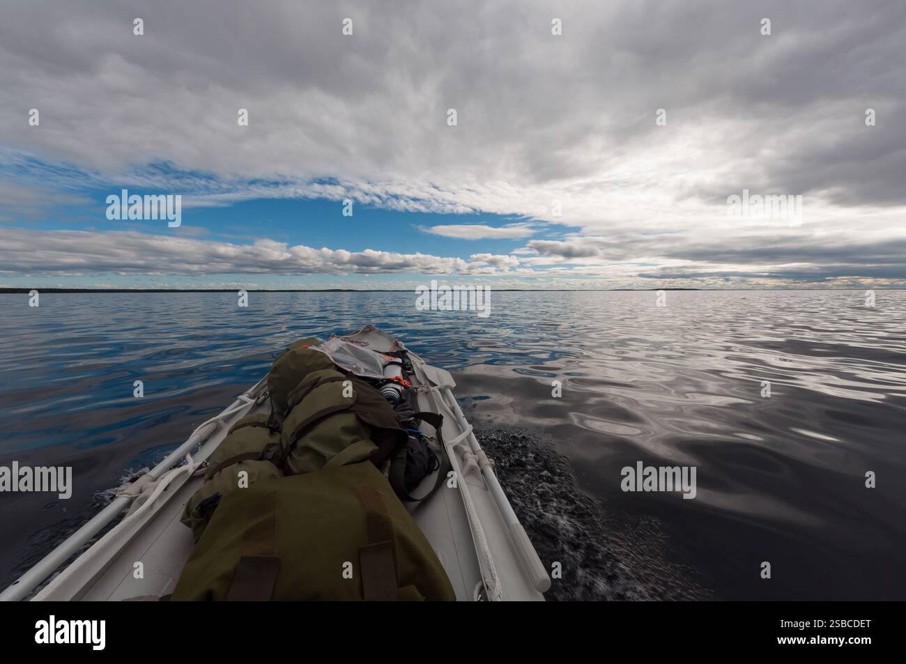 Driving a small inflatable boat on a large lake in Finnish Lapland in ...