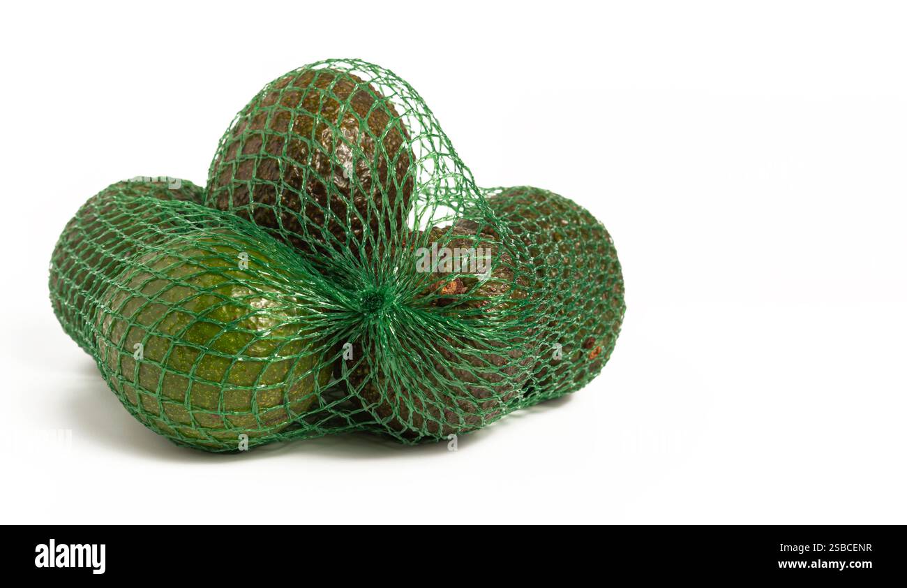 Avocados, tropical green fruit in mesh bag on white background Stock ...