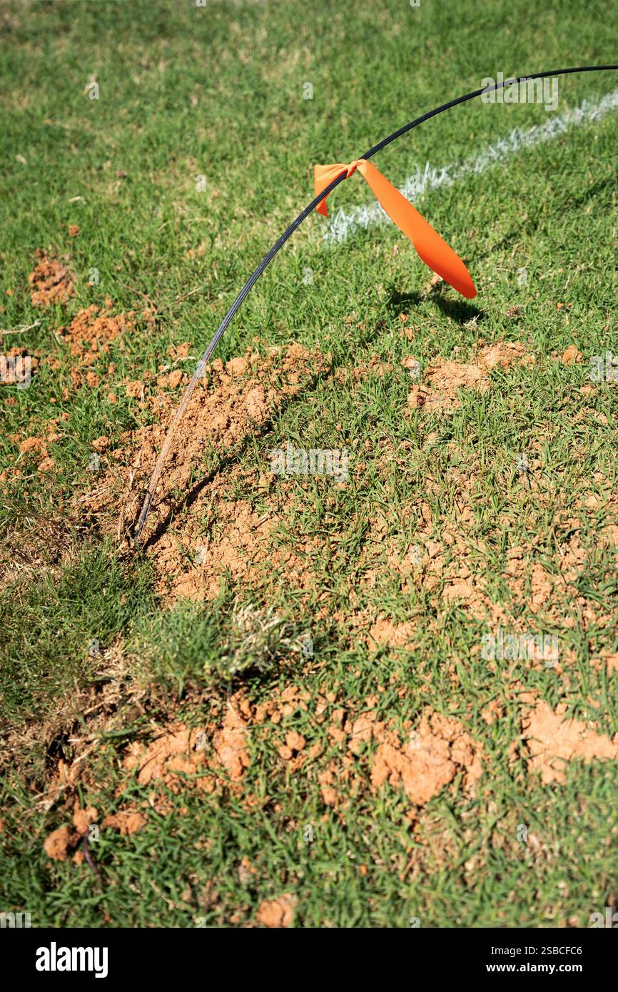 A new fiber optic cable line drop with a warning orange flag tied ...