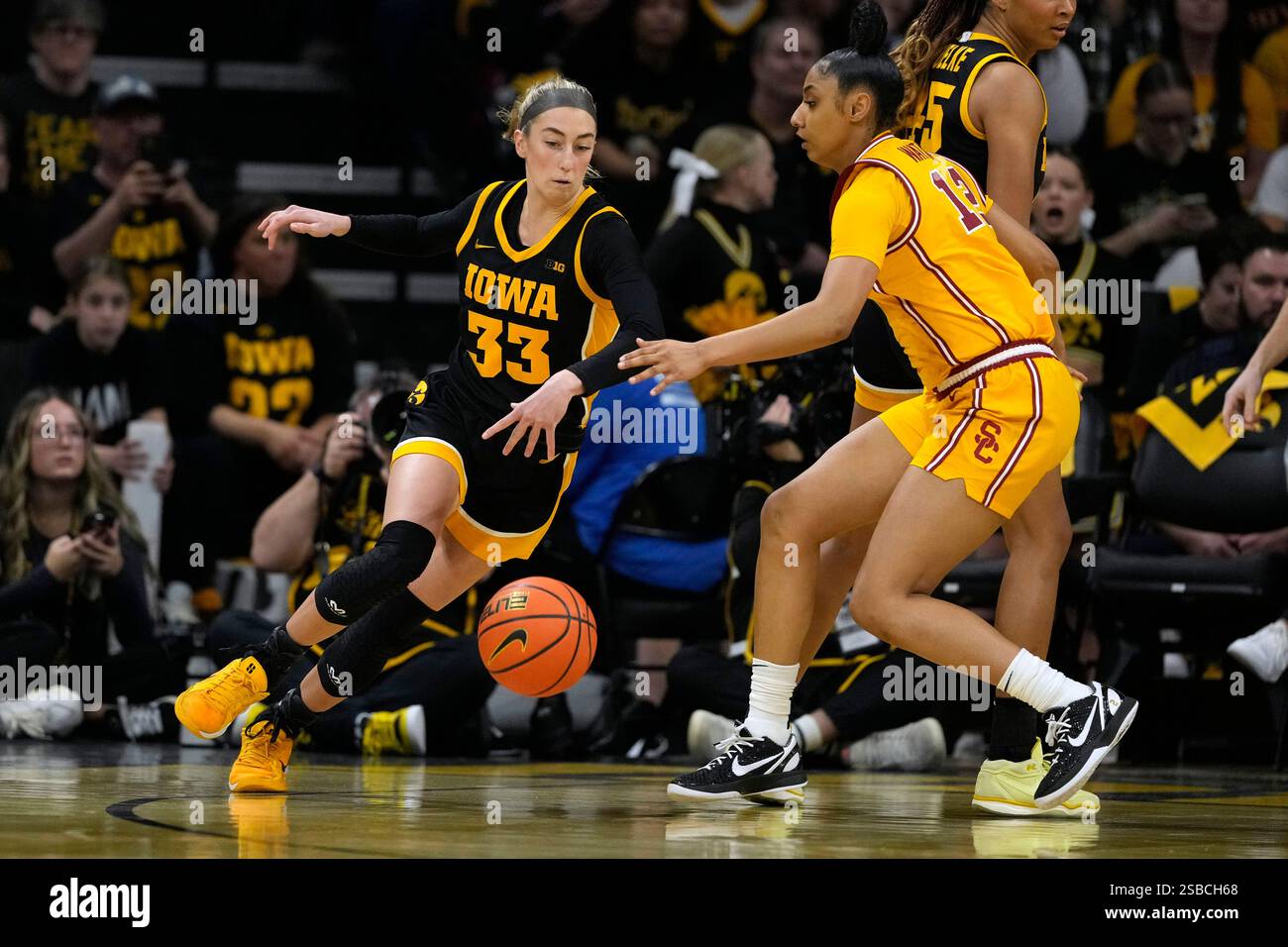 Iowa guard Lucy Olsen (33) drives around USC guard JuJu Watkins (12 ...