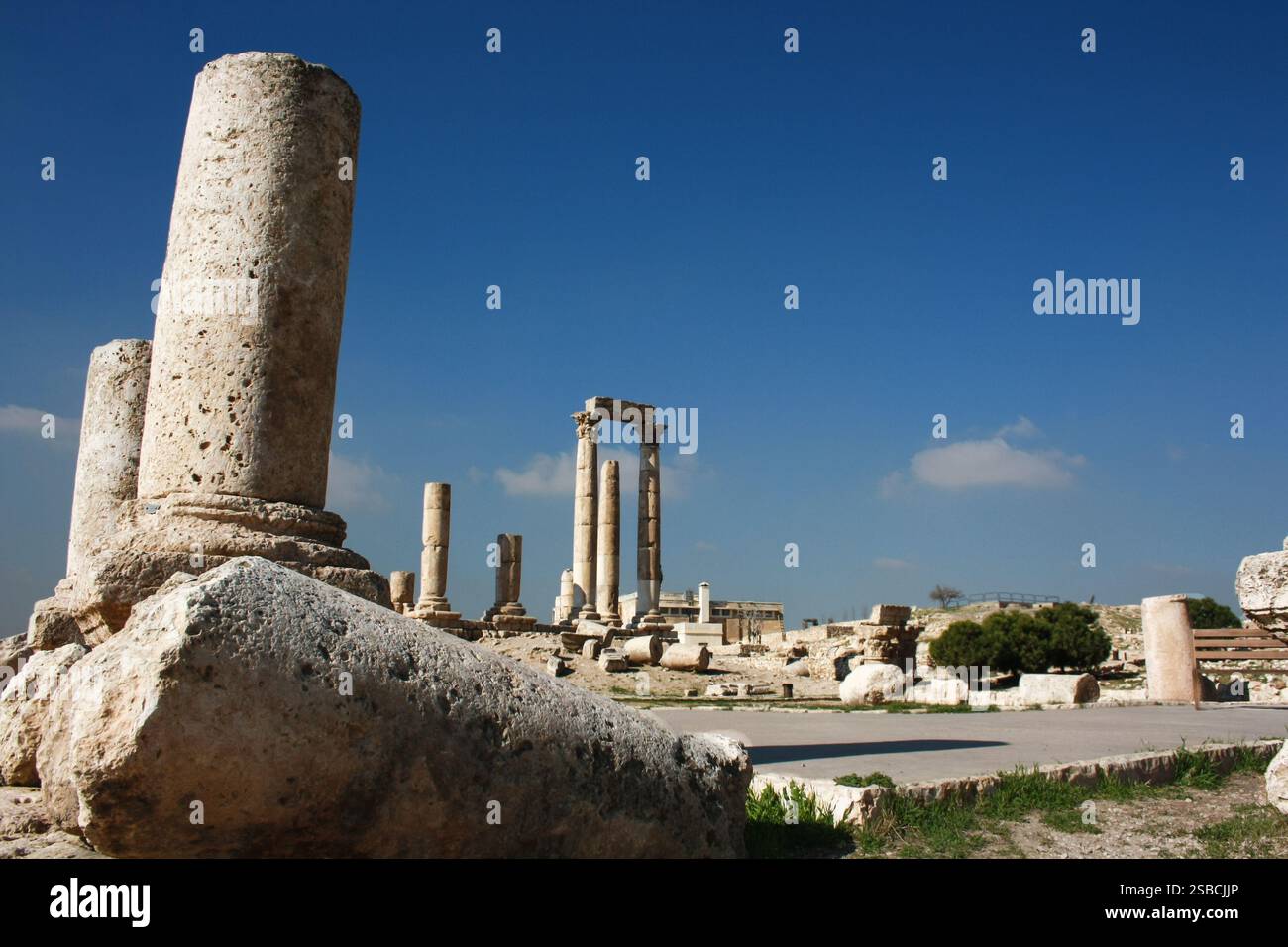 Weathered Roman pillars stand against the bright Jordanian sun in the ...