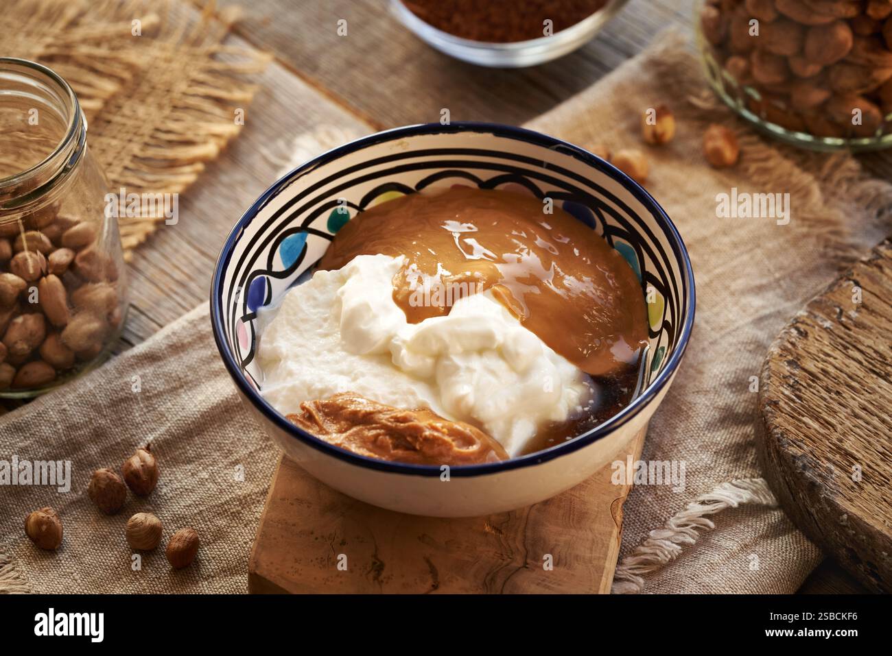 Greek yogurt in a bowl with nut butter, maple syrup and hazelnuts ...