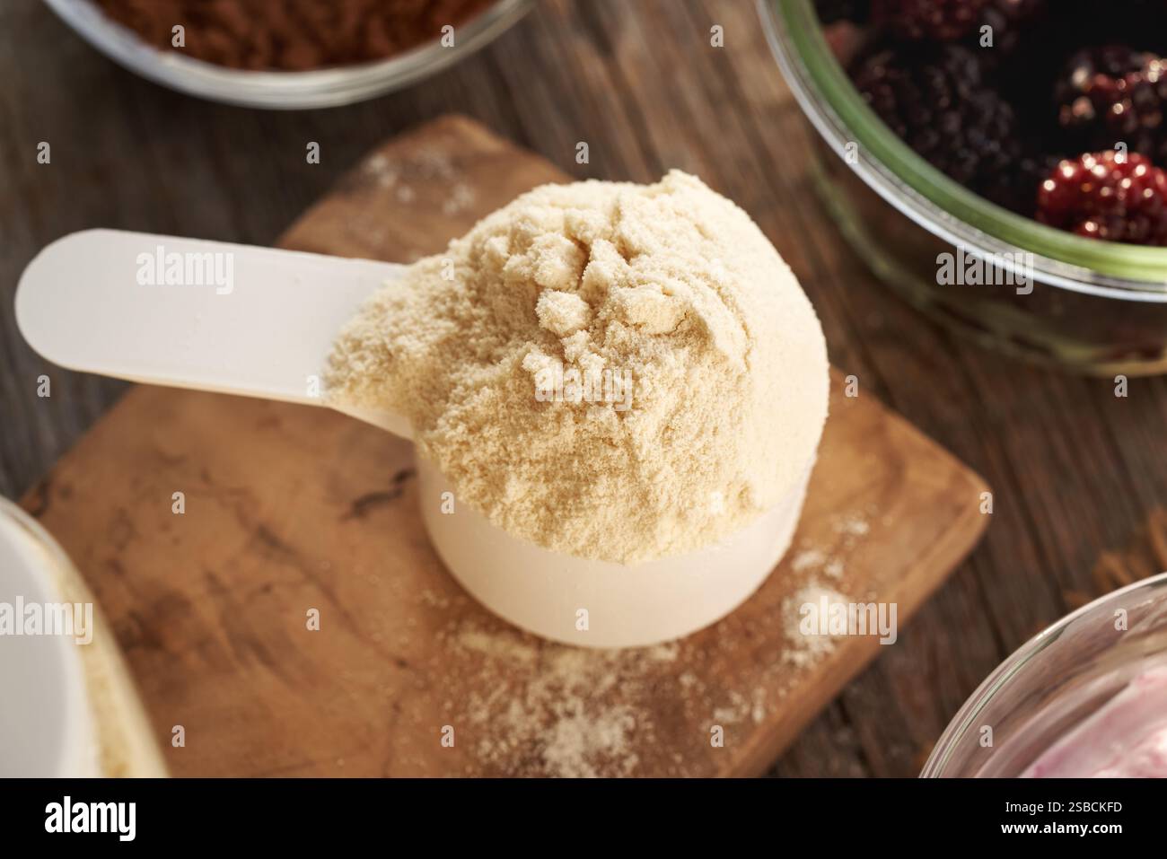 Whey protein powder in a measuring cup, with frozen cranberries in the ...