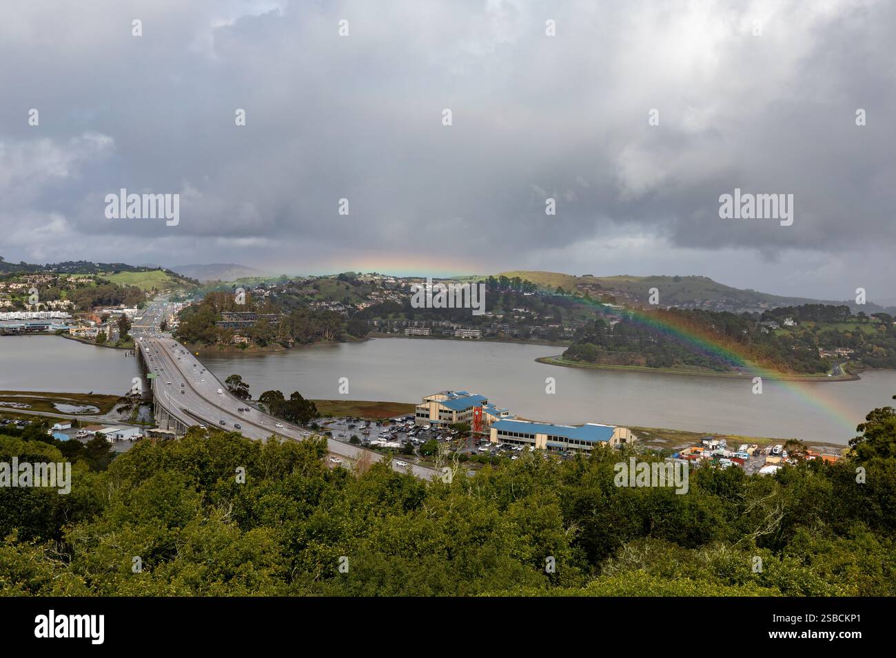 Rainbow over highway bridge and waterfront comminity in Marin Stock ...