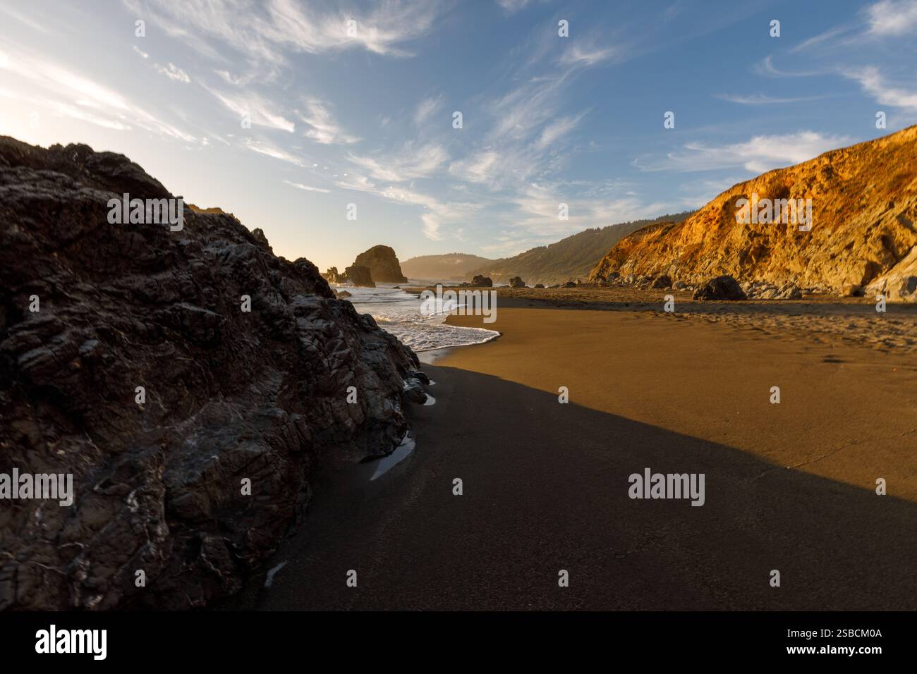 Sunset on rocky coastline beach Stock Photo - Alamy