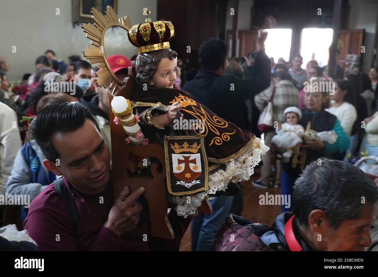 Parishioners carry figurines of Baby Jesus to the altar to be blessed ...