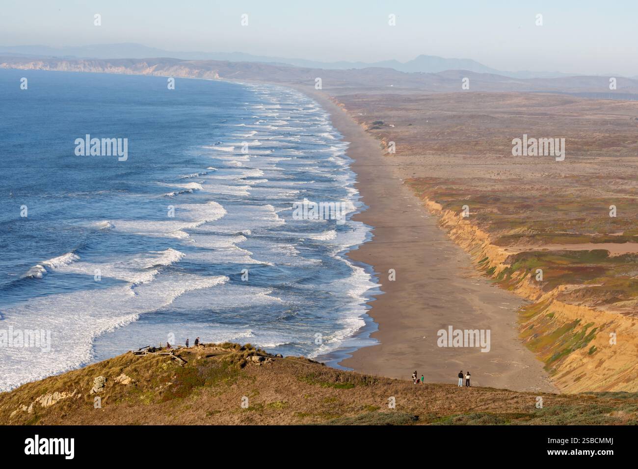 view from above of repeating pattern of waves crashing on the sandy ...