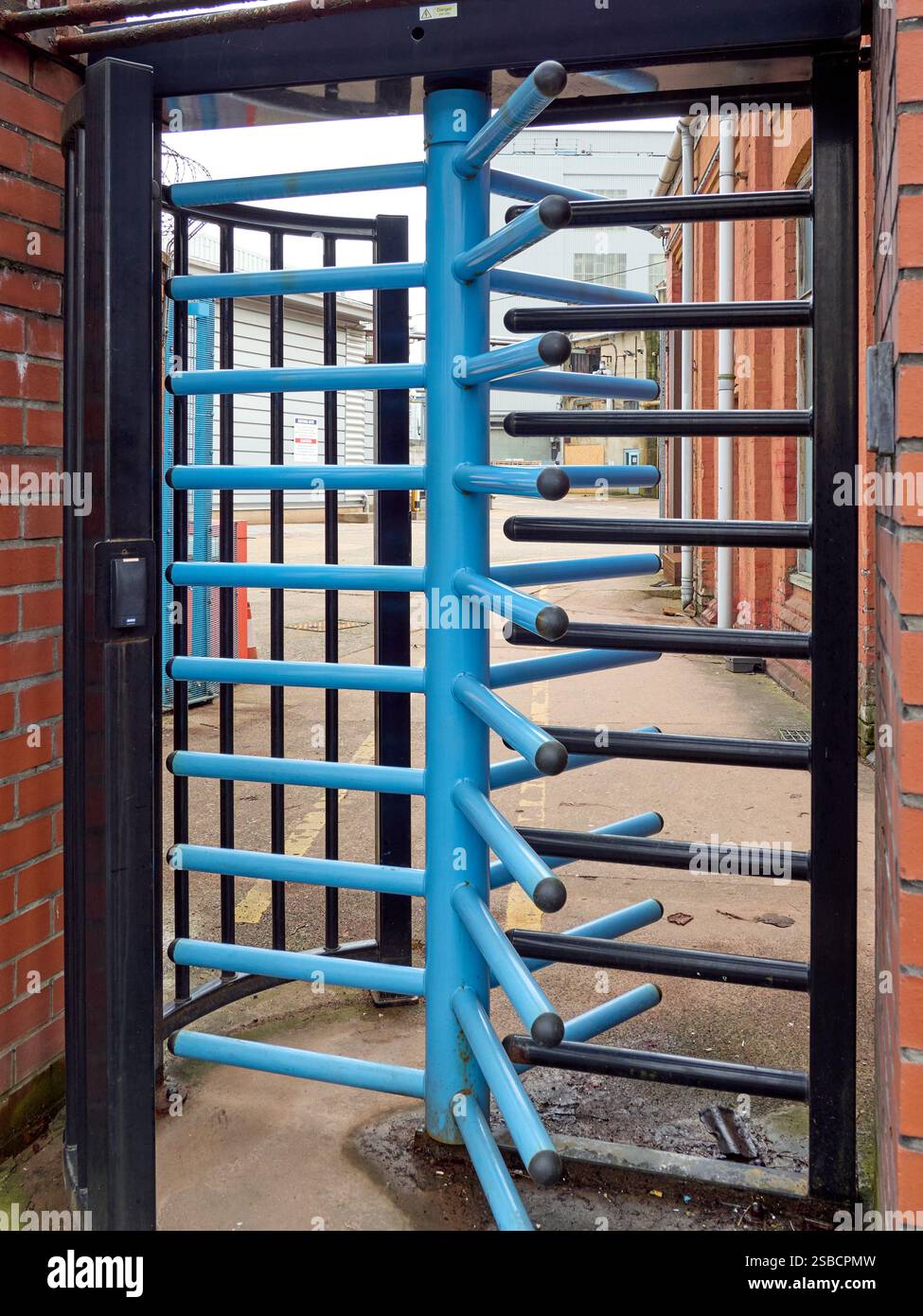 Blue turnstile works factory gate in an industrial outdoor setting ...