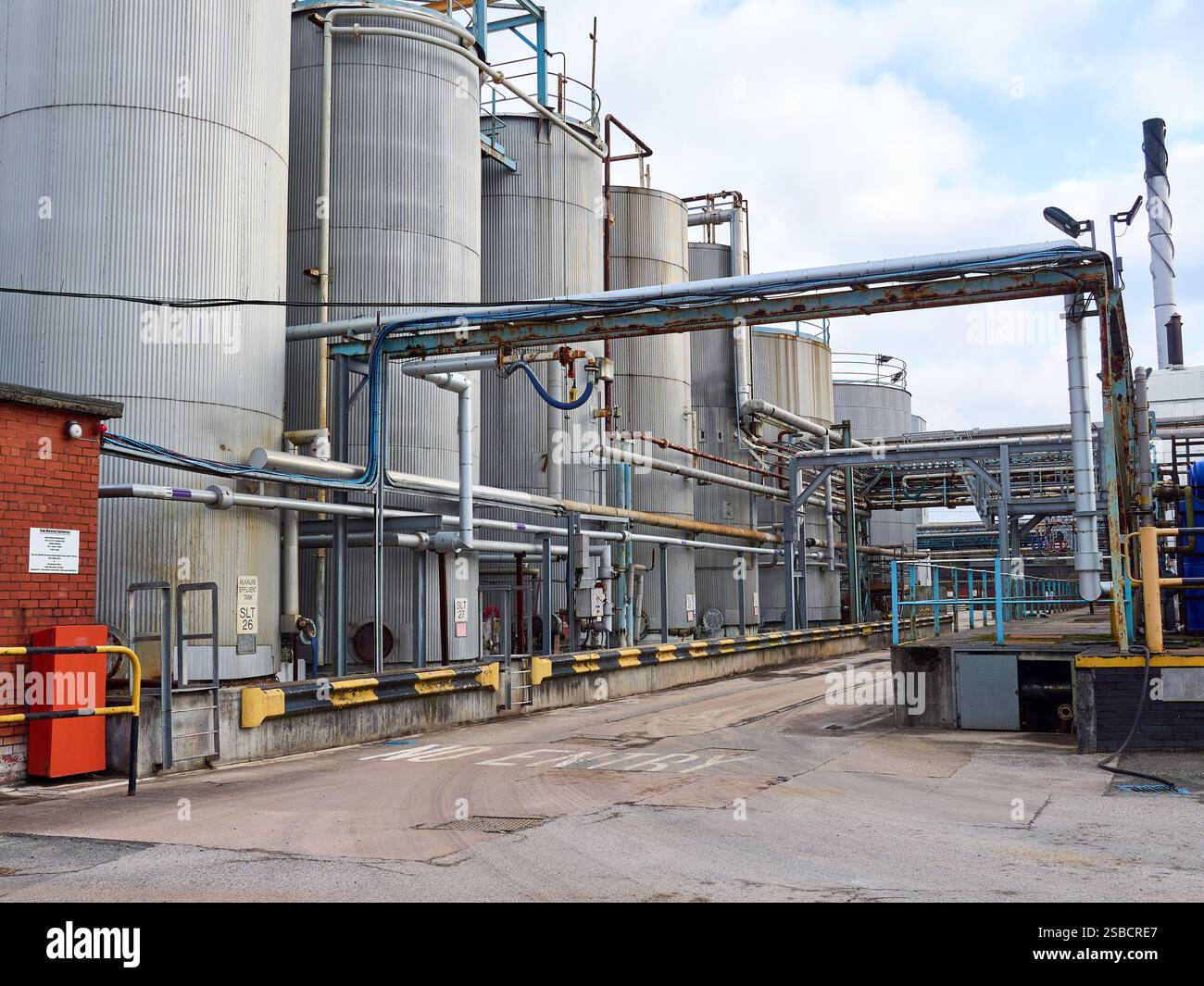 Industrial chemical plant with large storage tanks and intricate piping ...