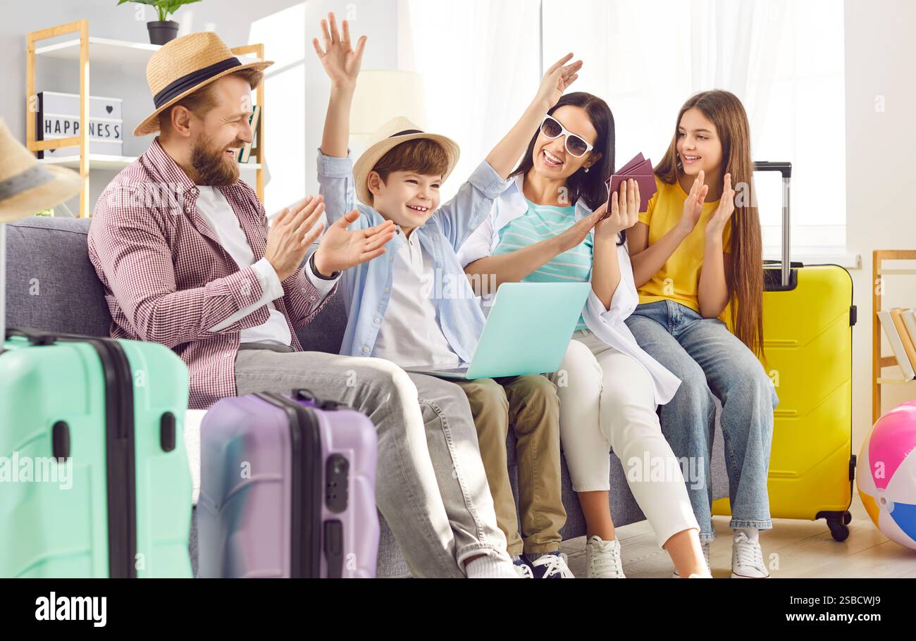 Happy family buying tickets and booking hotel online using laptop ...