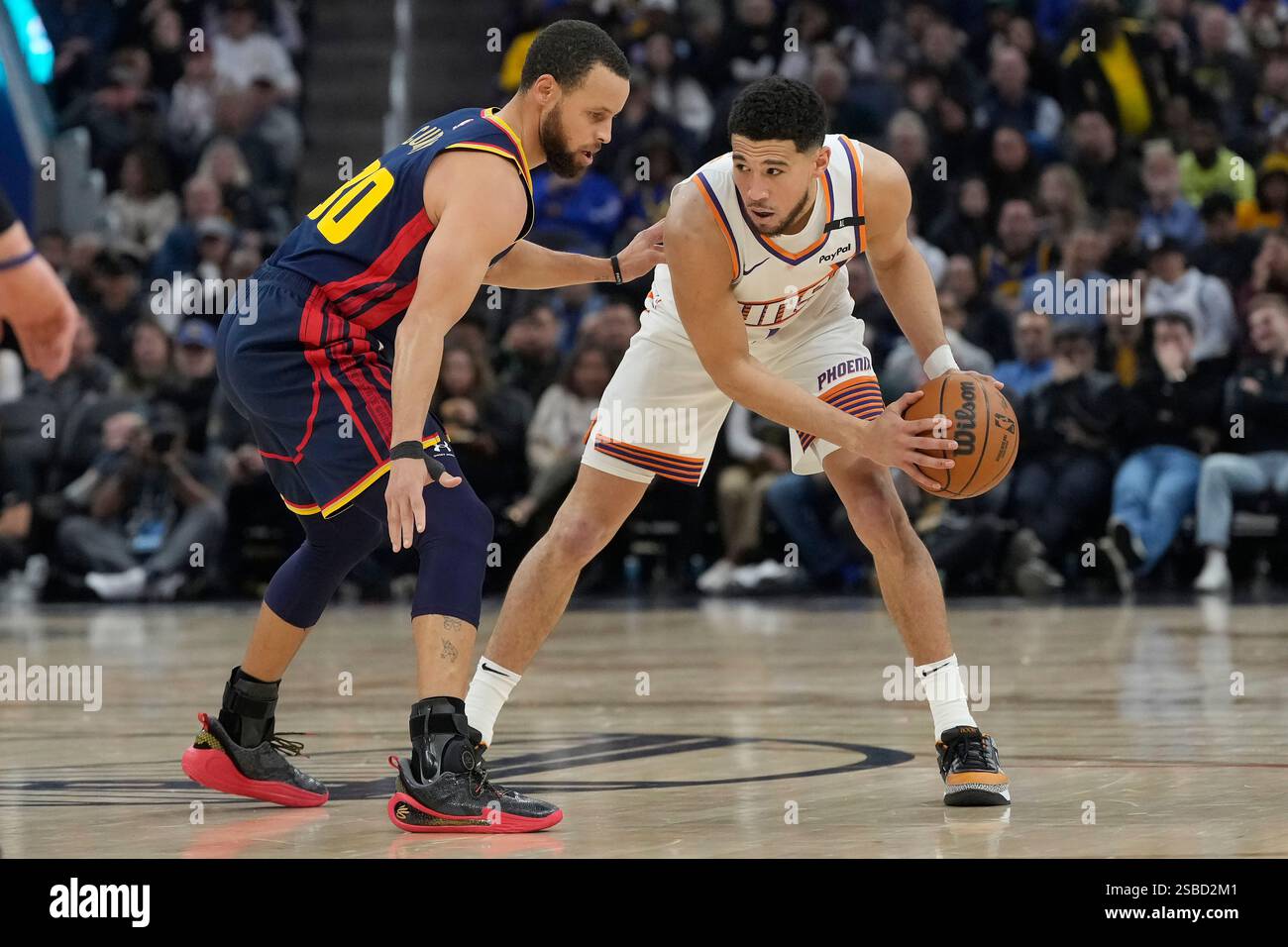 Phoenix Suns guard Devin Booker, right, is defended by Golden State ...