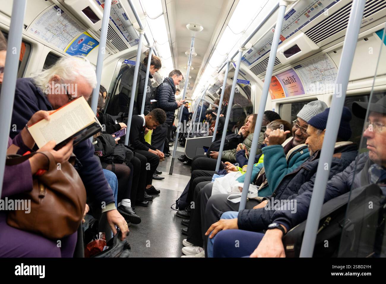 People passengers sitting woman reading book on underground tube ...
