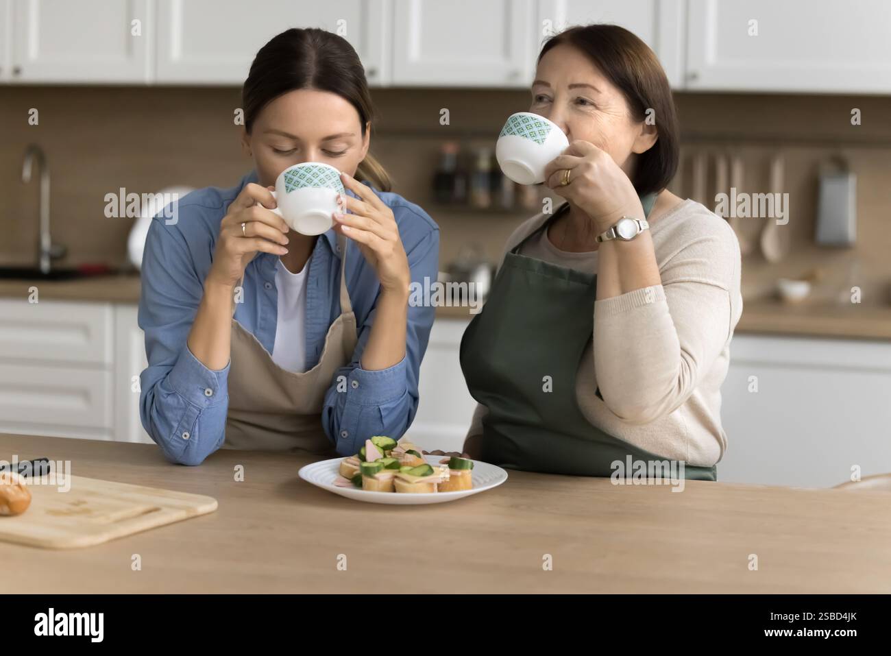 Family drinking morning tea, eating sandwiches in the kitchen Stock ...