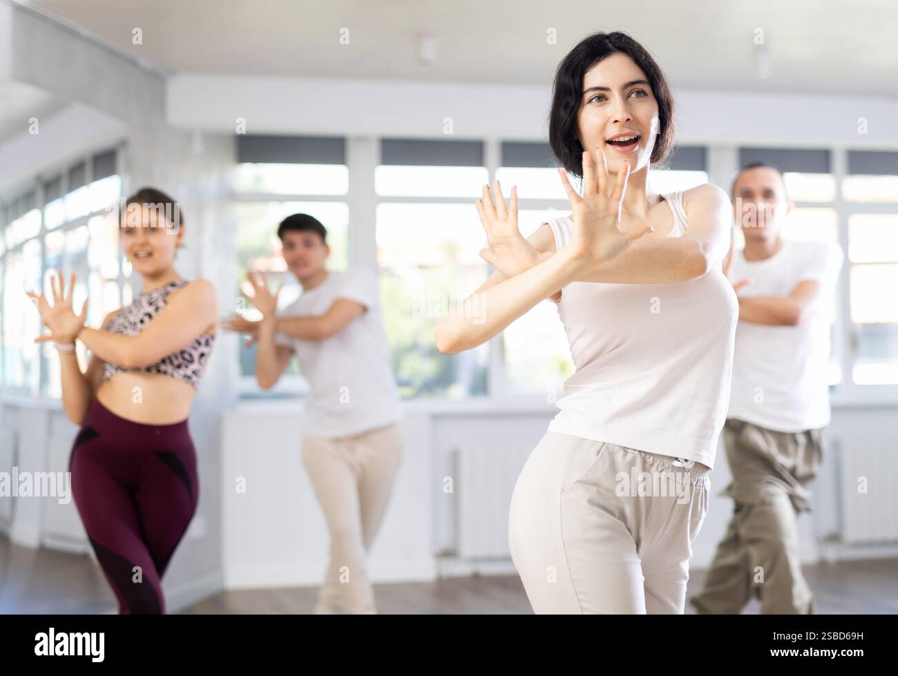 Happy emotional young female dancer rehearsing popping techniques ...