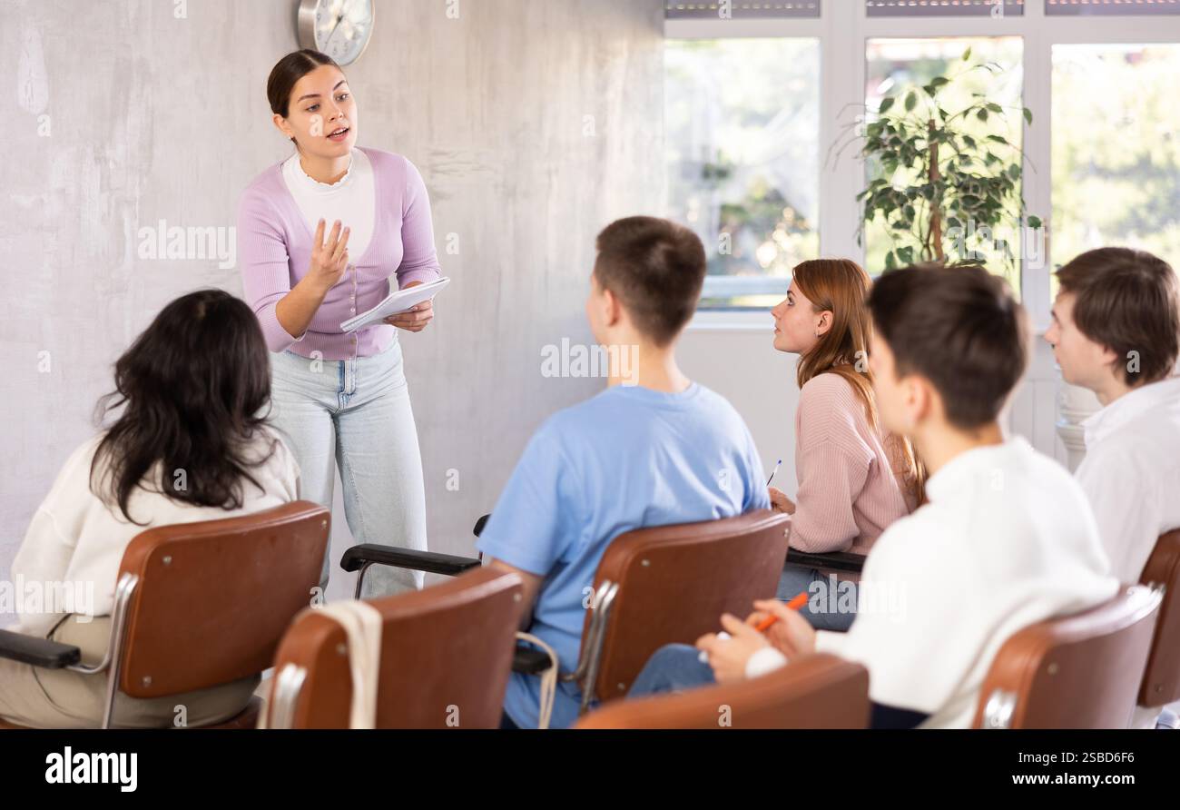 While working in classroom, female teacher answers questions that ...