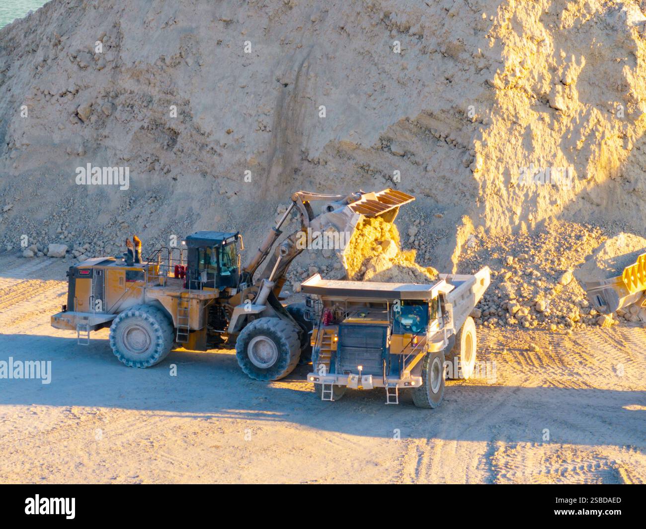 Wheel loaders loading rock into a dump truck at a quarry Stock Photo ...