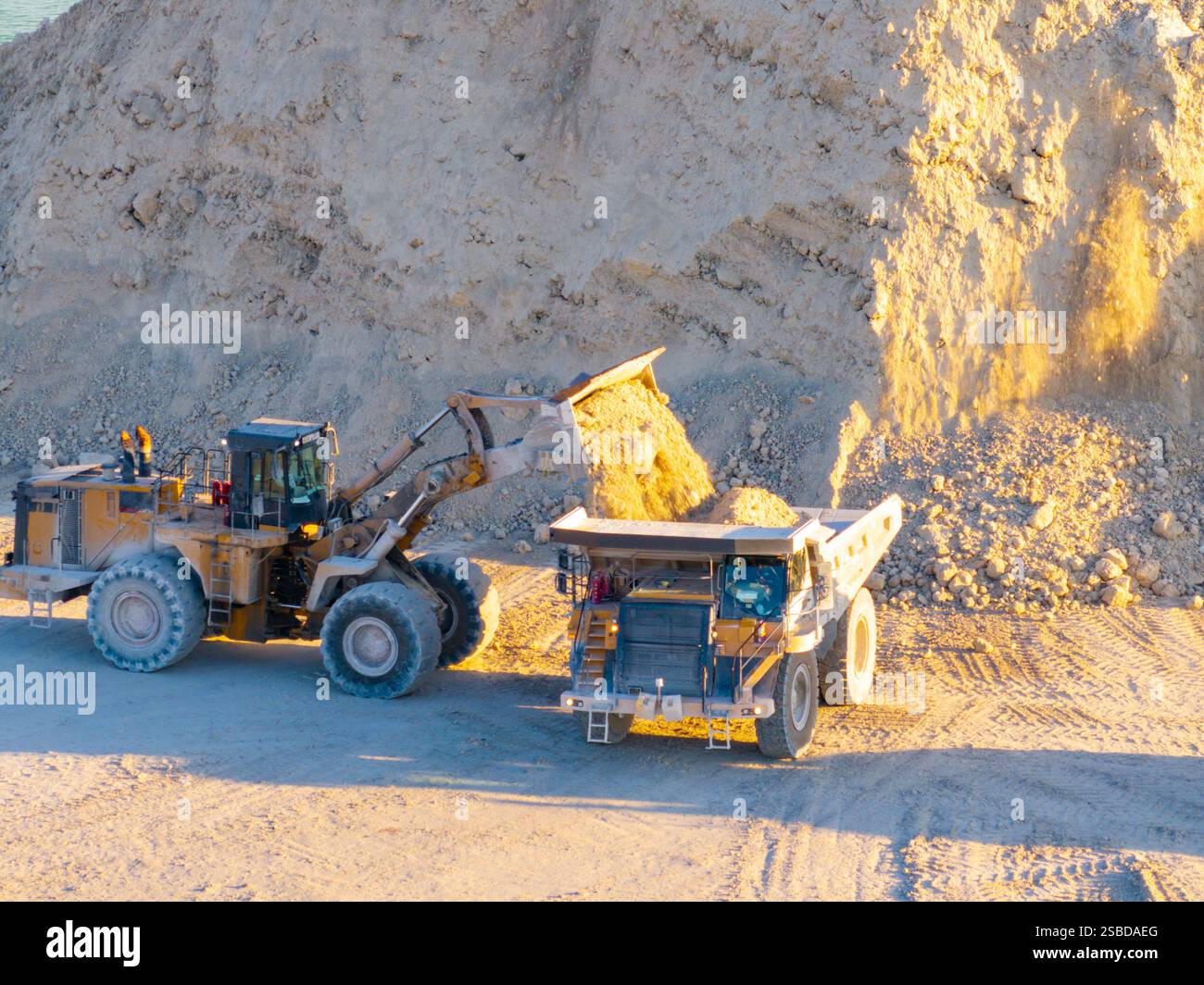 Wheel loaders loading rock into a dump truck at a quarry Stock Photo ...