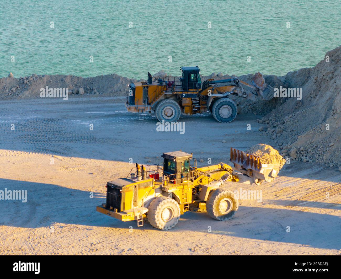 Wheel loaders loading rock into a dump truck at a quarry Stock Photo ...