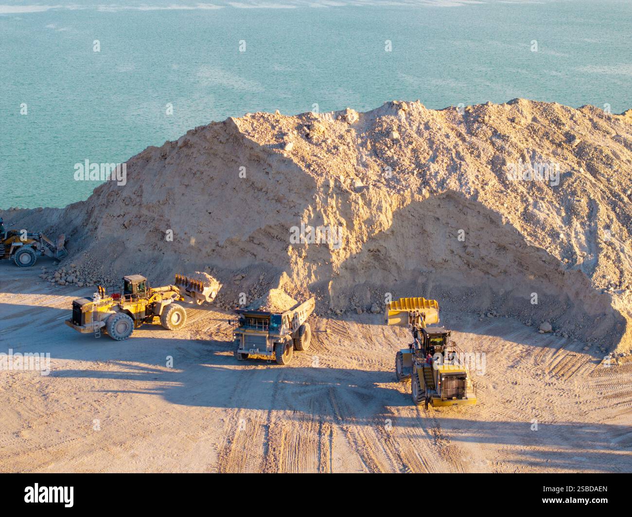 Wheel loaders loading rock into a dump truck at a quarry Stock Photo ...