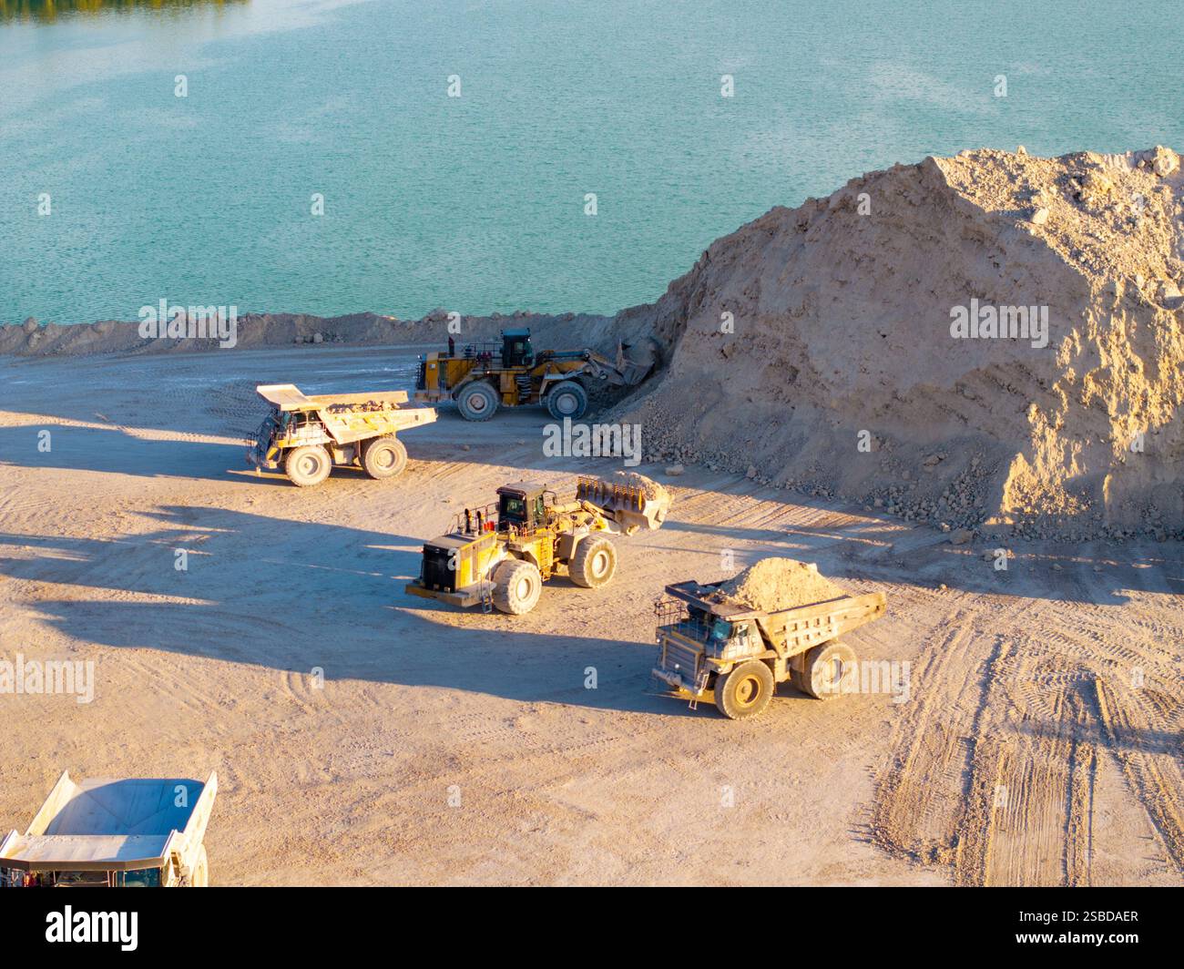 Wheel loaders loading rock into a dump truck at a quarry Stock Photo ...