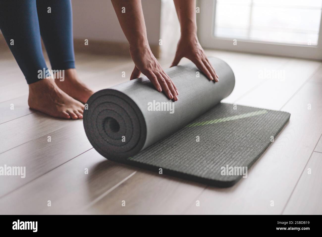 Yoga woman folding roll mat before after meditation practice training ...