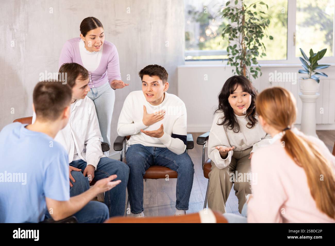Group of students engaged in discussion in classroom Stock Photo - Alamy