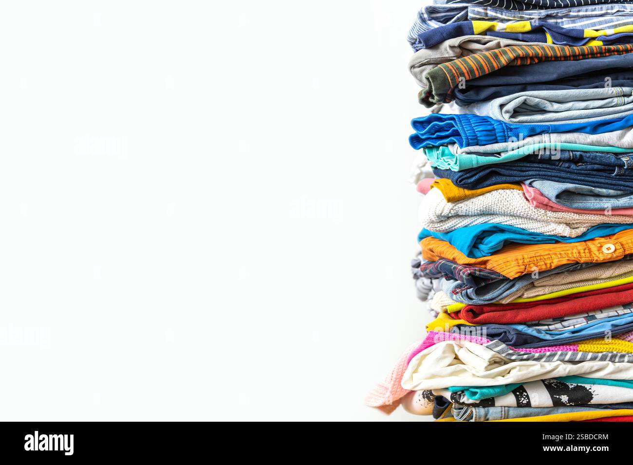 A very tall stack of folded colored clothes for charity, washing ...