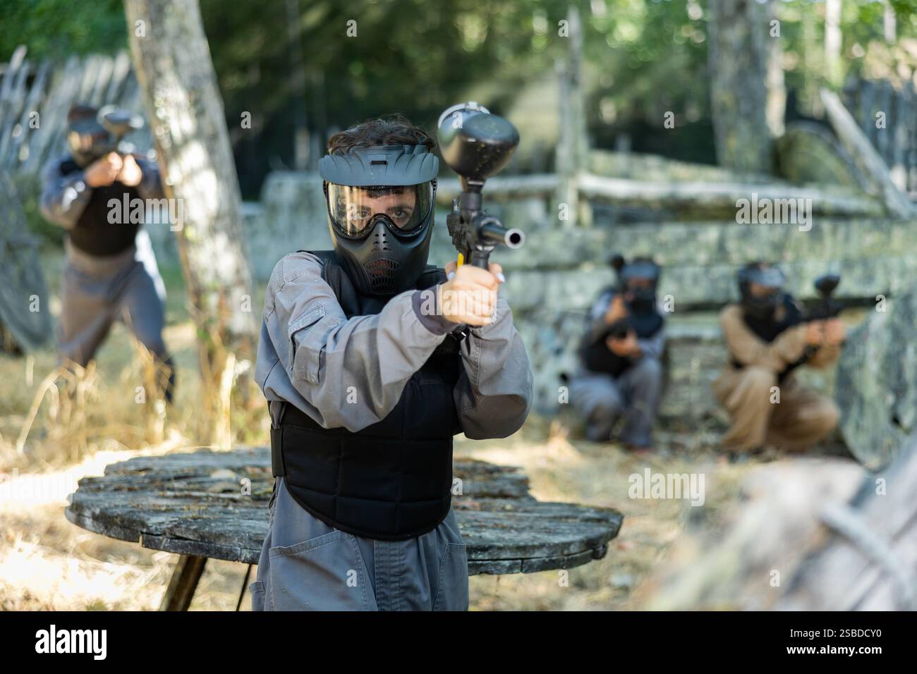 Woman targeting and shooting with paintball gun Stock Photo - Alamy